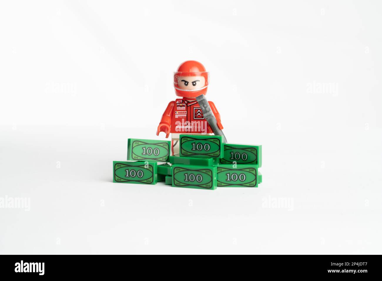 Lego figurine of a race car driver standing in front of lego 100 dollar ...