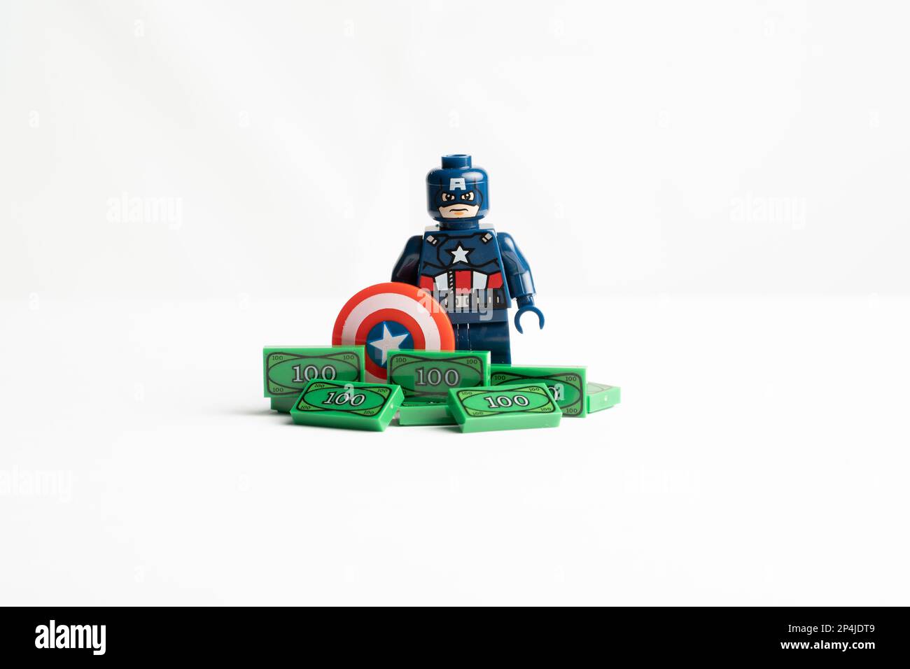 A Lego figure of Captain America, standing in front 100 dollar bills on ...