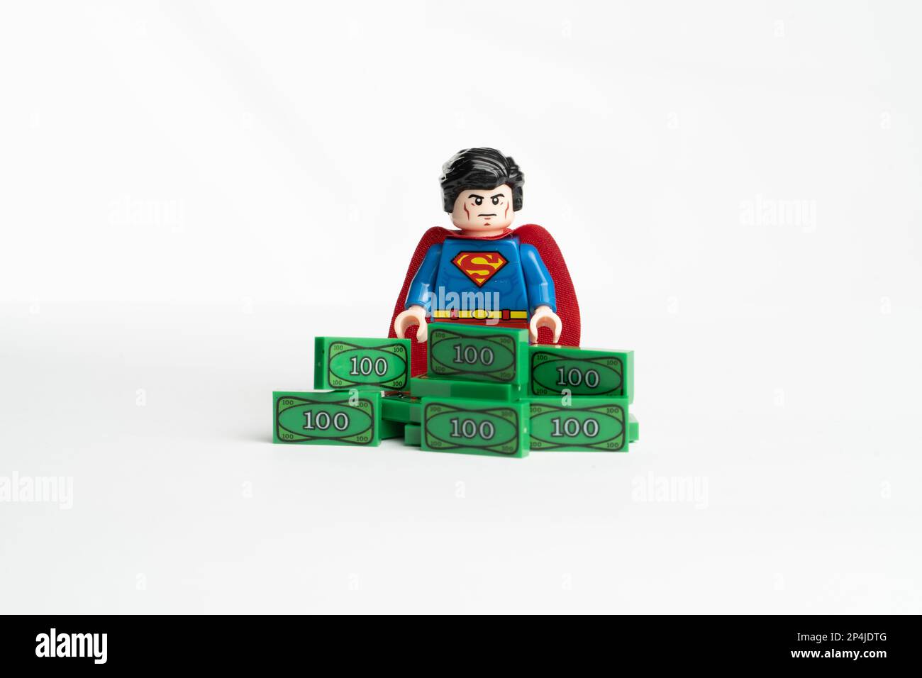 a lego figurine of superman standing in front of lego 100 dollar bills ...