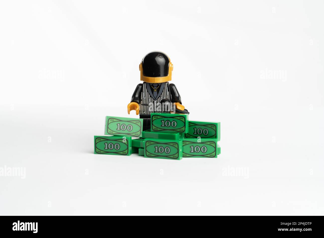 A Lego robot holding a microphone standing in front of a pile of lego ...