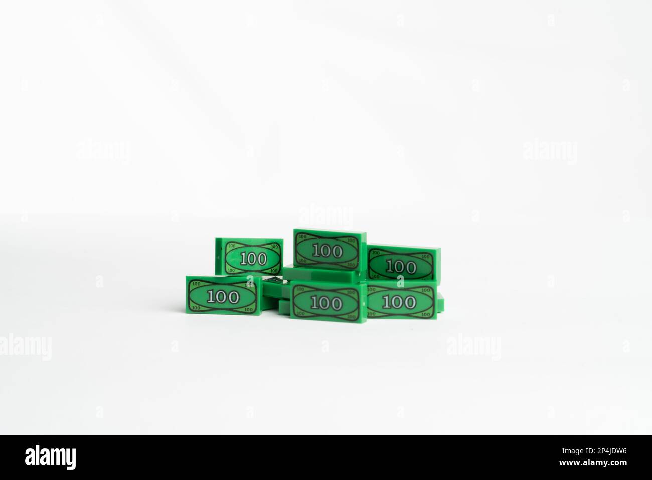 A close up of lego 100 dollar bills on an isolated white background ...