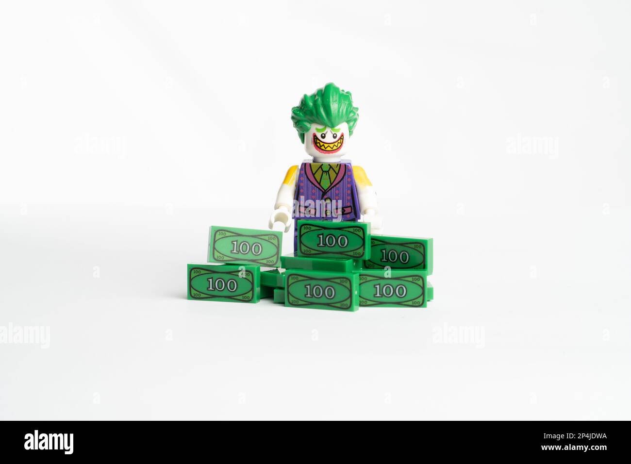 Lego figurine of the joker standing in front of lego 100 dollar bills ...