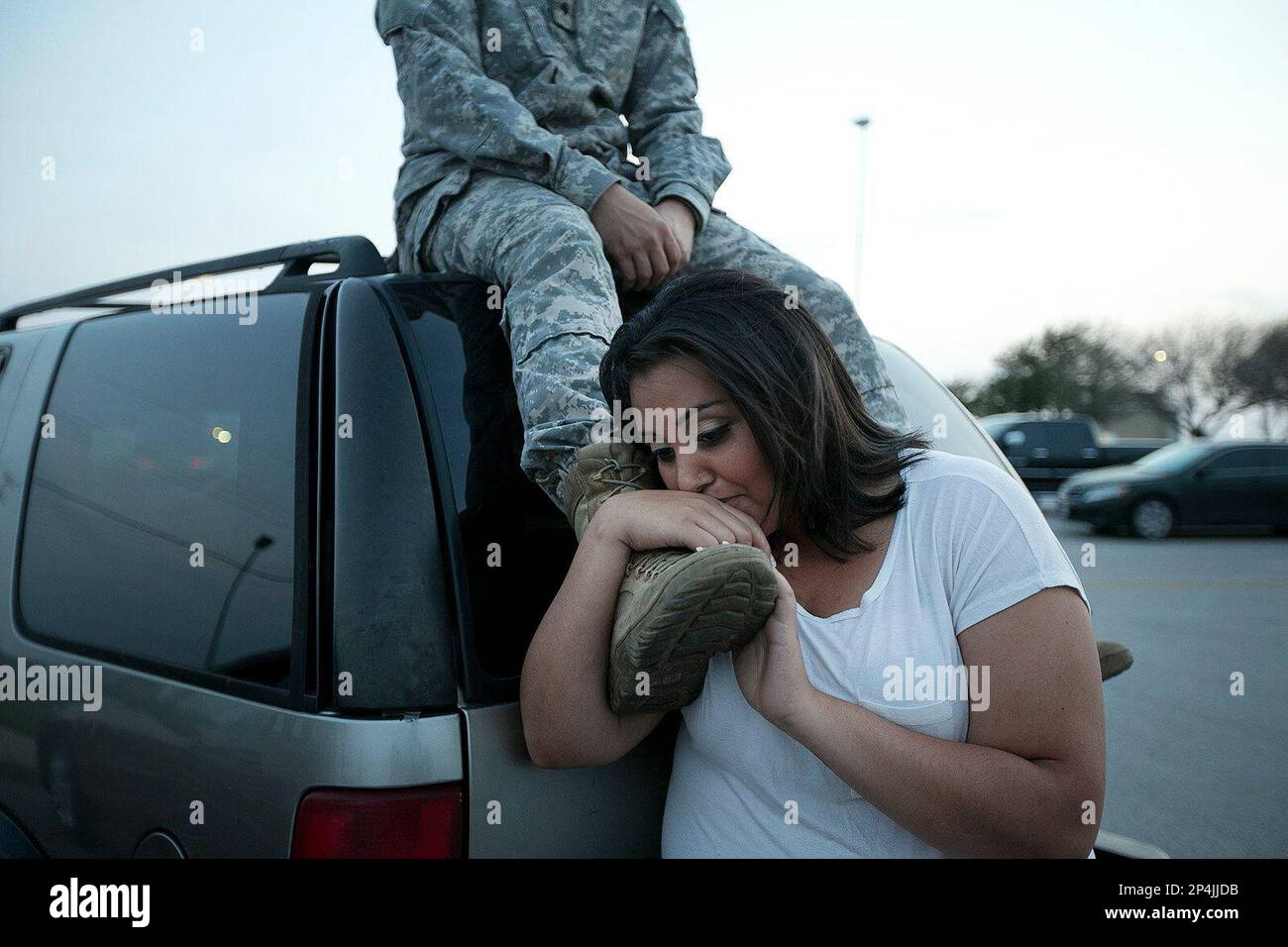 Lucy Hamlin leans on her husband's foot, Specialist Timothy Hamlin, as they wait to be allowed ...