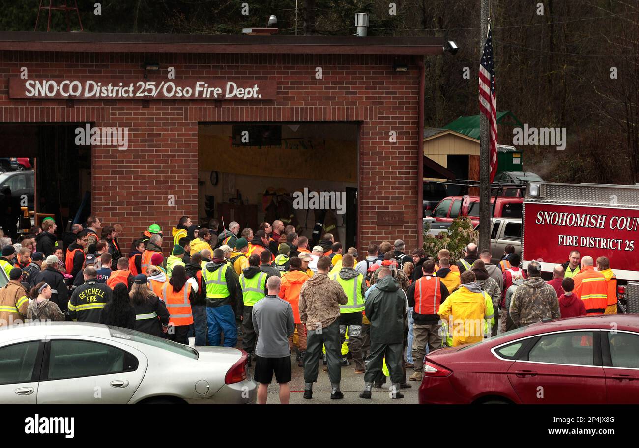 Workers and volunteers observe a moment of silence outside of the Oso ...
