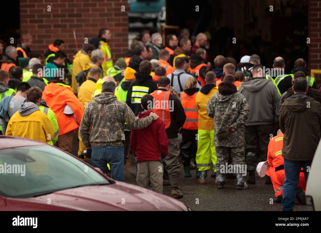 Workers and volunteers observe a moment of silence outside of the Oso ...