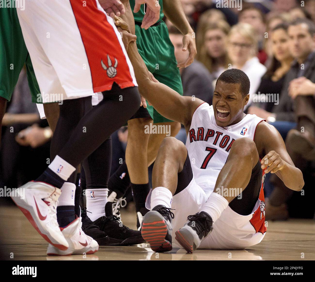 Toronto Raptors guard Kyle Lowry lets out a yell as he is helped up ...