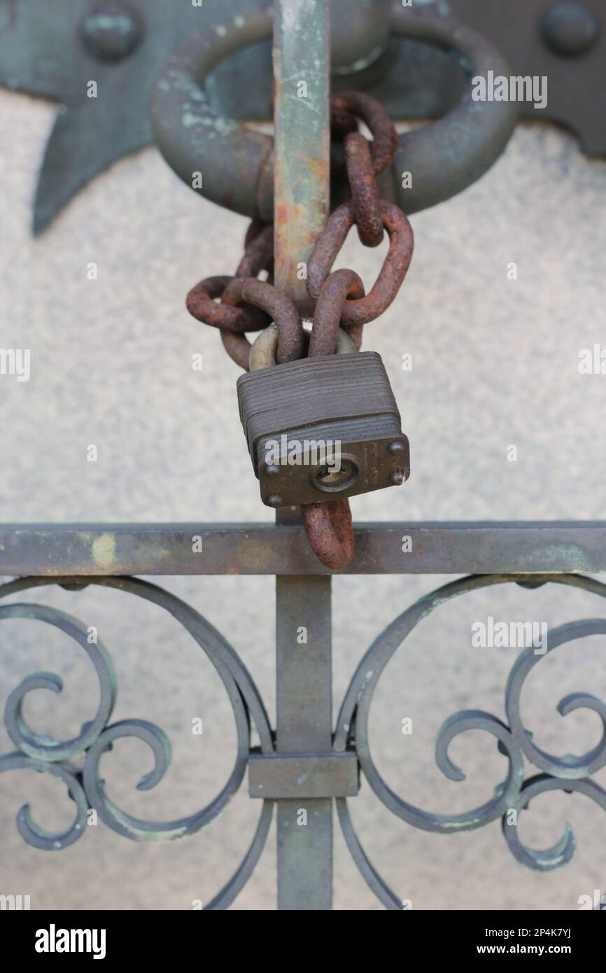 A padlock and chain keeping a fancy copper gate closed and locked Stock ...