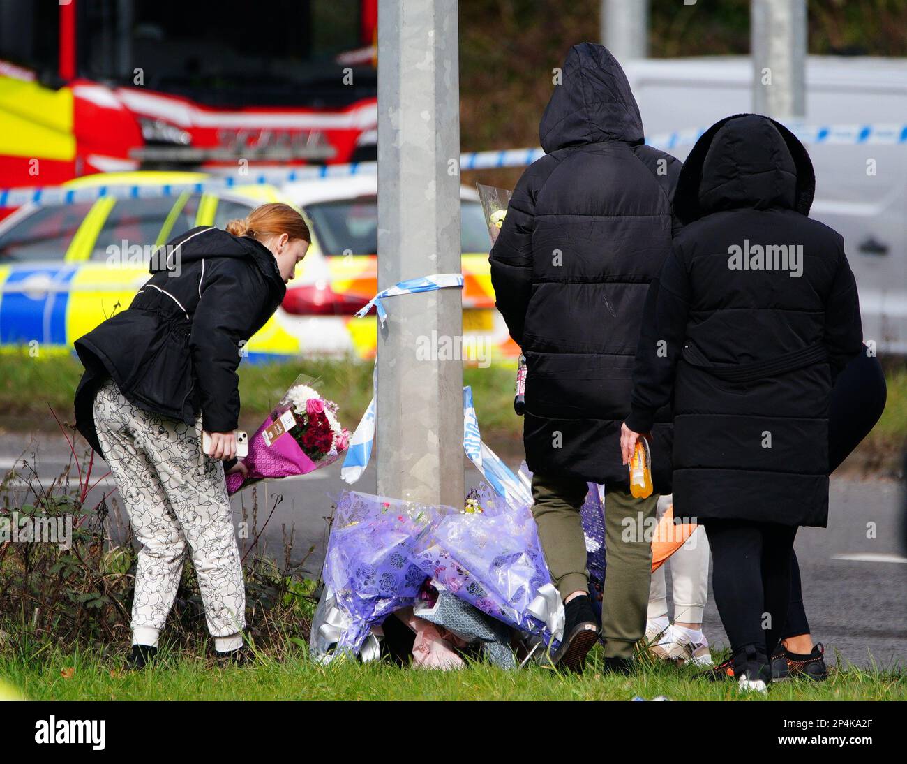 A group of people lay floral tributes left near the scene in the St ...