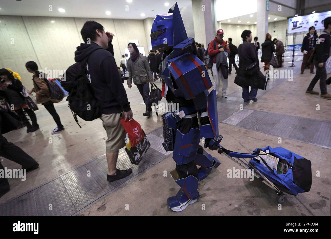 A costume player, or cosplayer, with cardboard-made robot costume walks ...