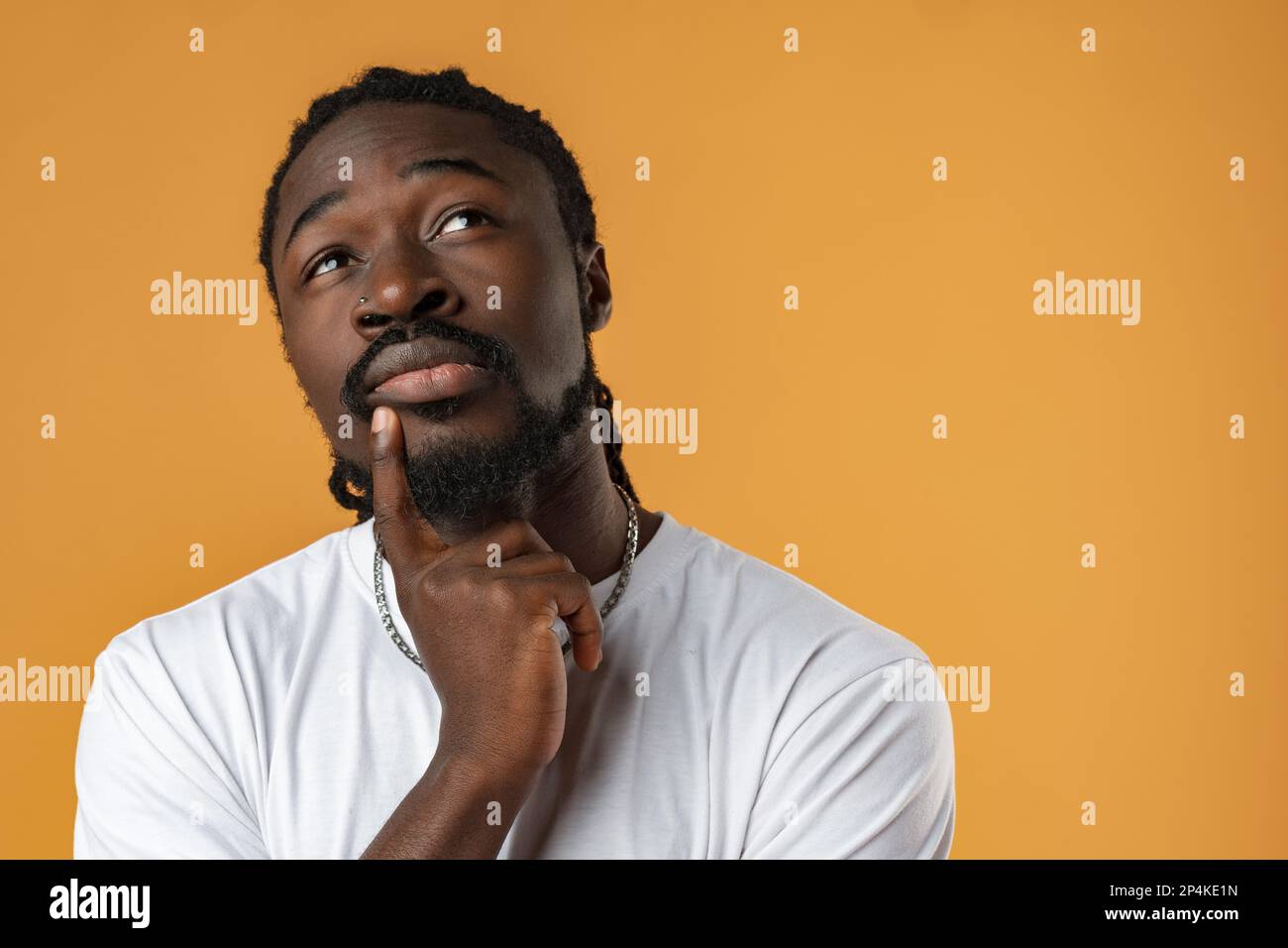 Young african guy thinking about something over yellow background Stock ...