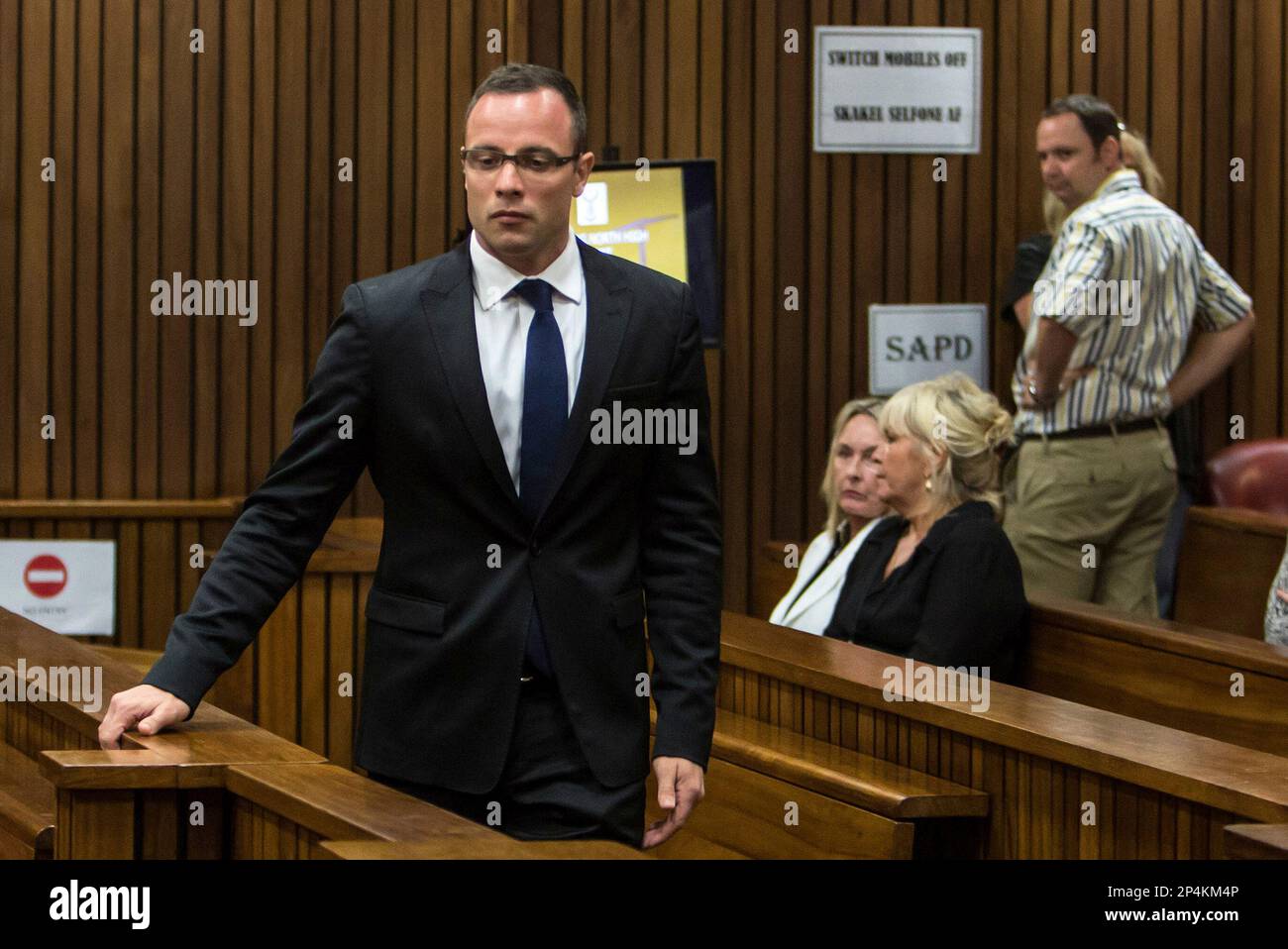 Oscar Pistorius, left, walks past June Steenkamp, back left, mother of ...