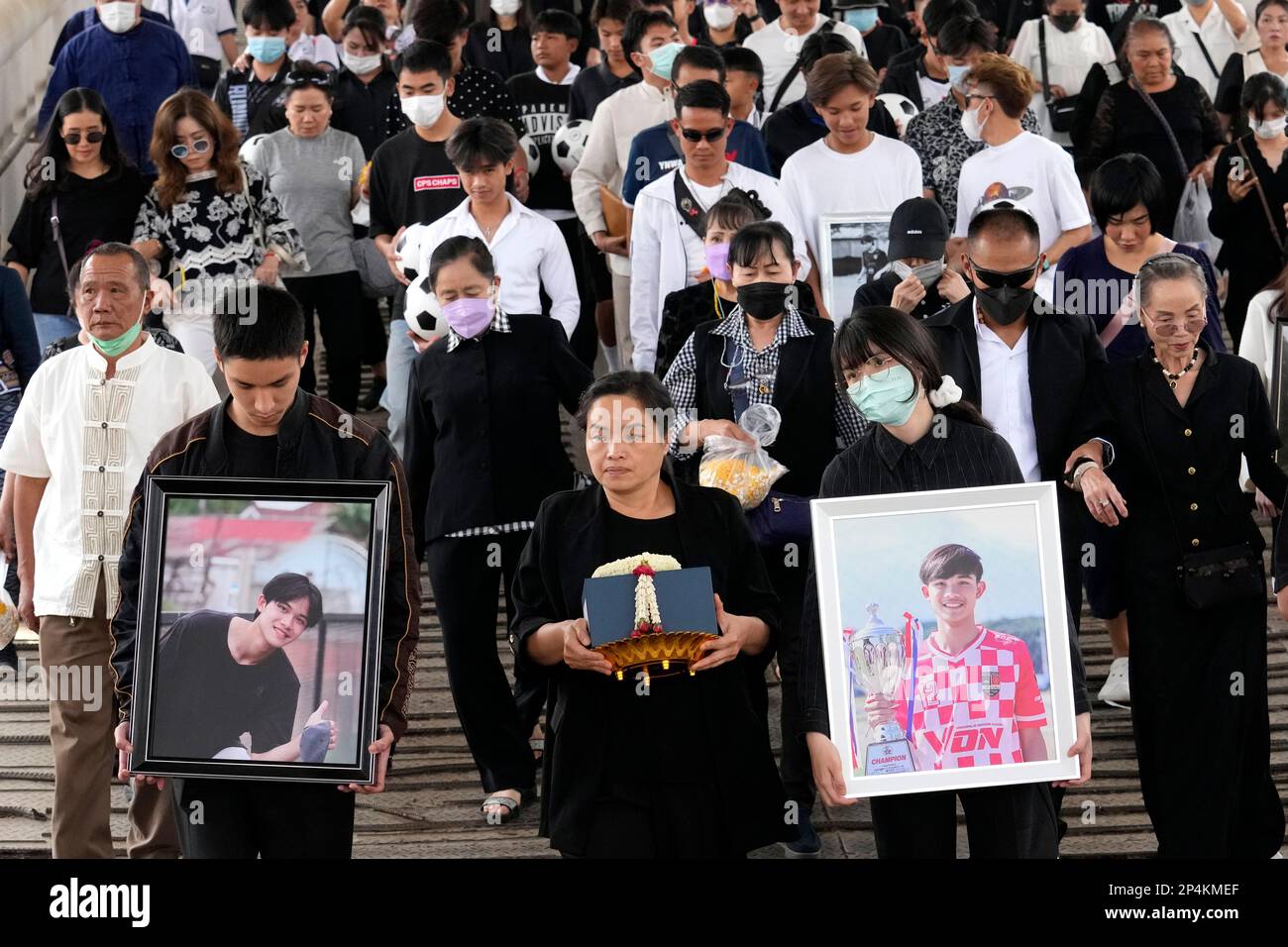 Family members hold the portrait of Duangphet Phromthep and ashes ...
