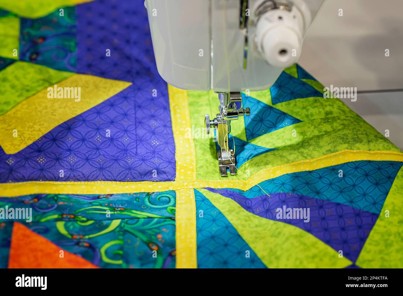 Closeup of detail of sewing machine with needle and on fabric sewn in ...