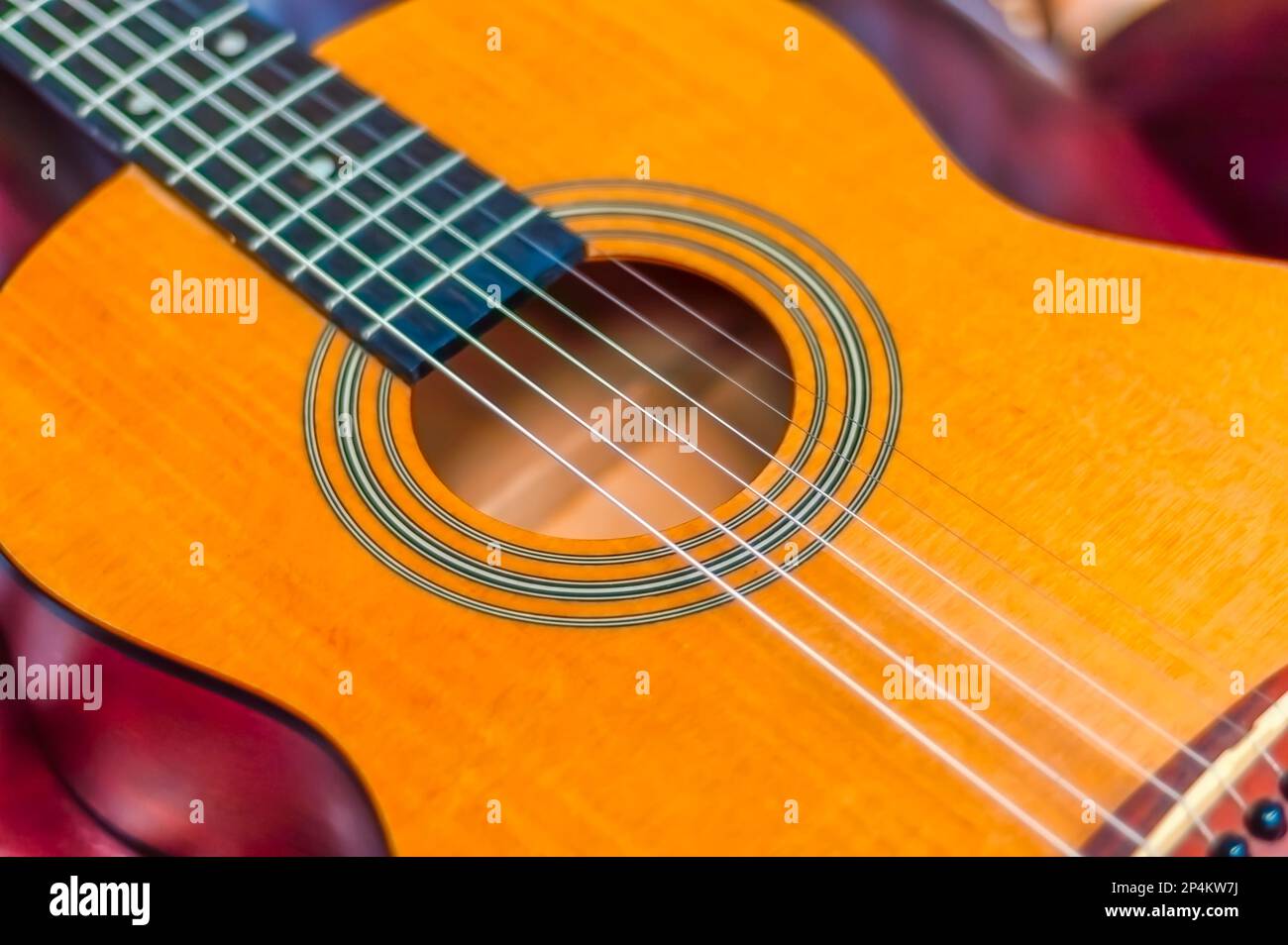 A close up of classical acoustic guitar with nylon strings, lying on a ...