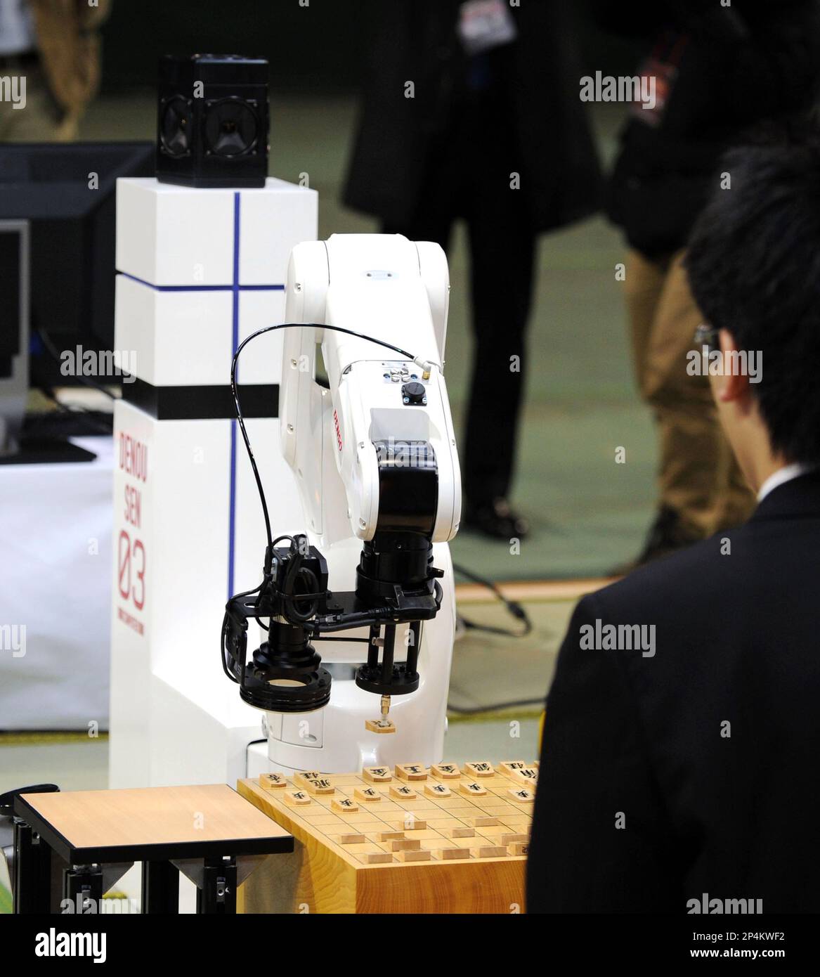 A shogi (Japanese chess) playing robot arm faces a professional player ...