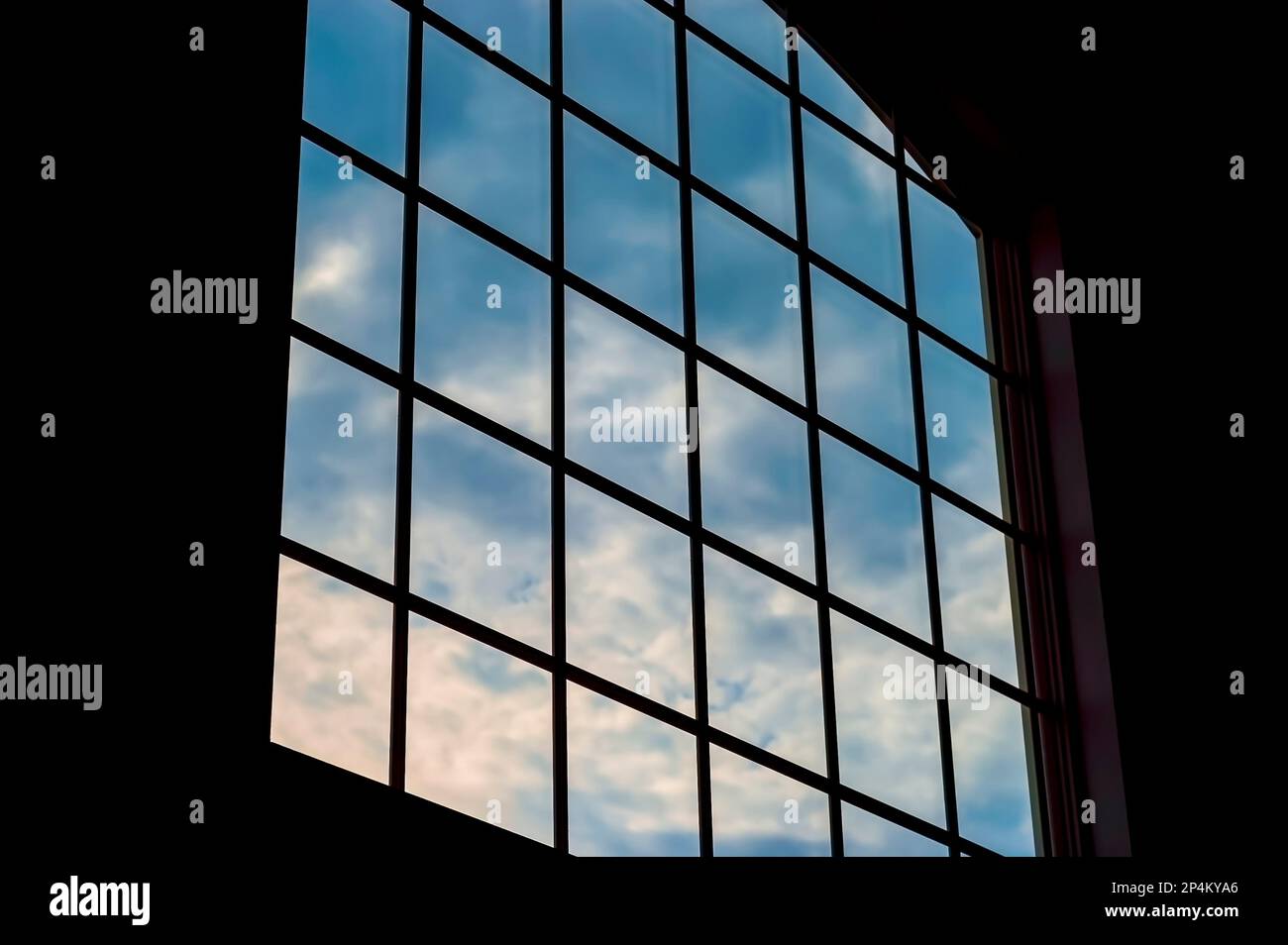 A view of the sky with clouds through a large window with numerous ...
