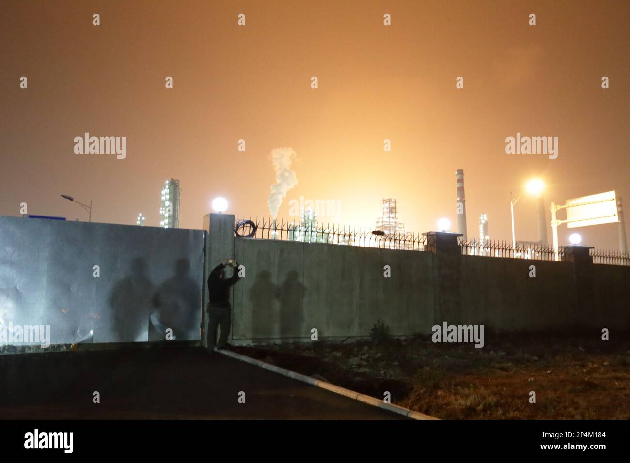A man takes photos of the oil refinery and chemical plant built by the ...