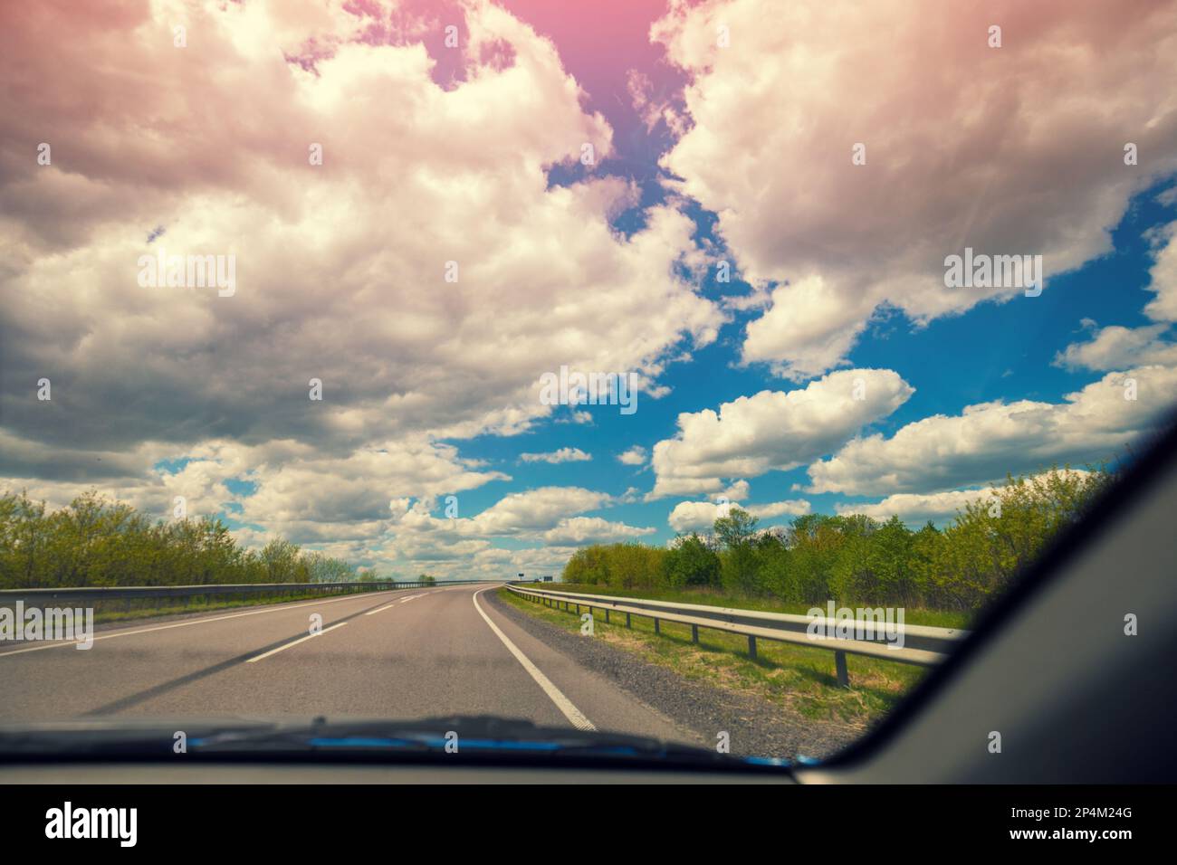 Highway with cloudy sky in summer. View of the road through the ...