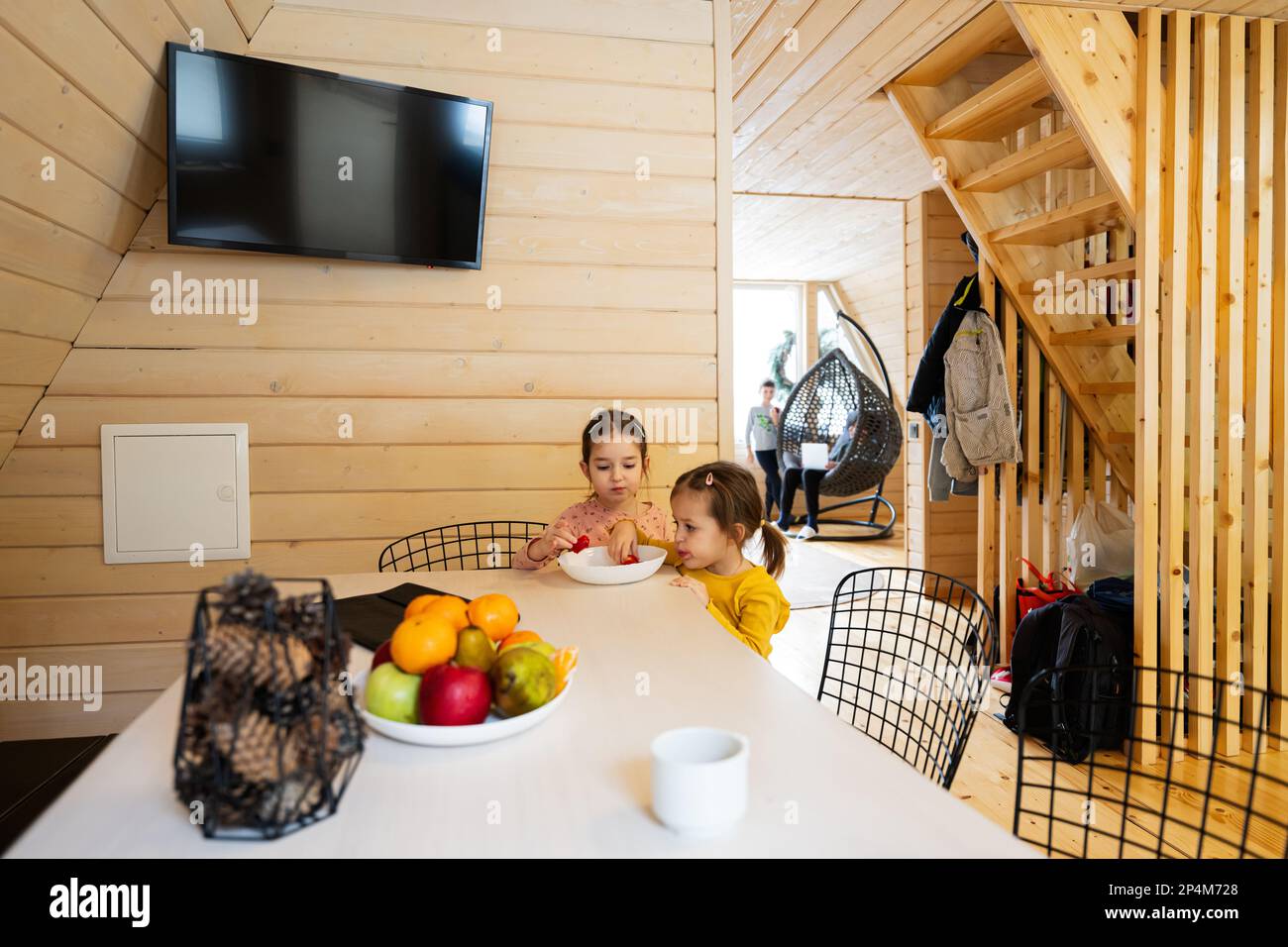 Two sisters eat strawberries in wooden country house on weekend Stock ...