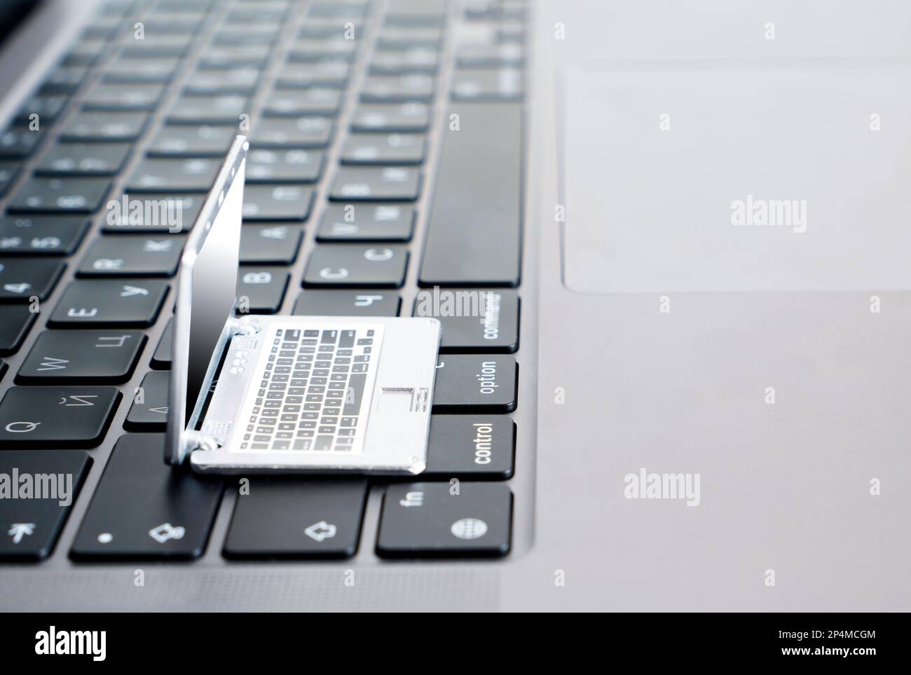 Miniature laptop positioned on the keyboard of a full-sized laptop ...