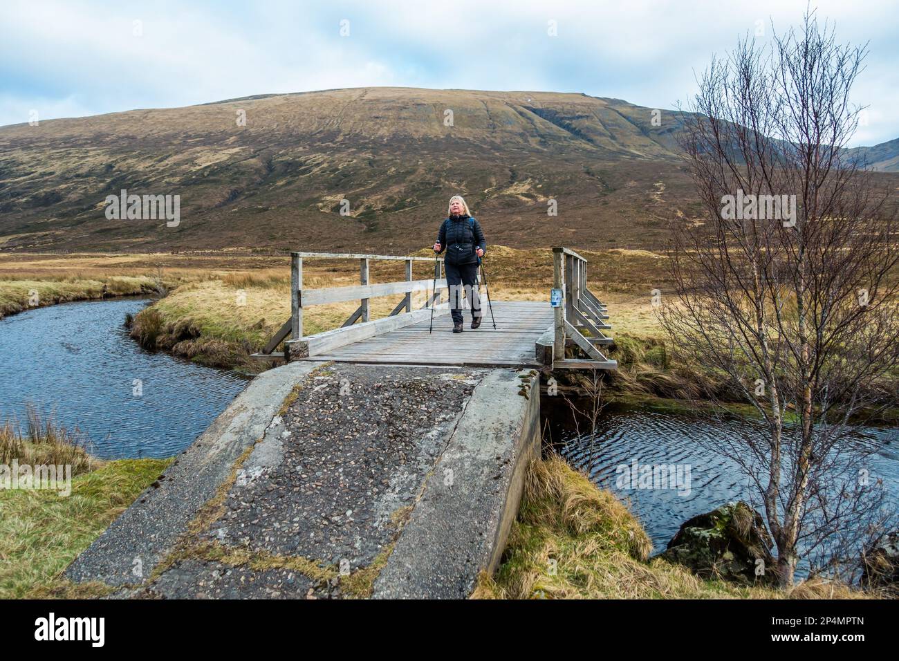 A walker crosses the bridge over the River Carron after descending the ...