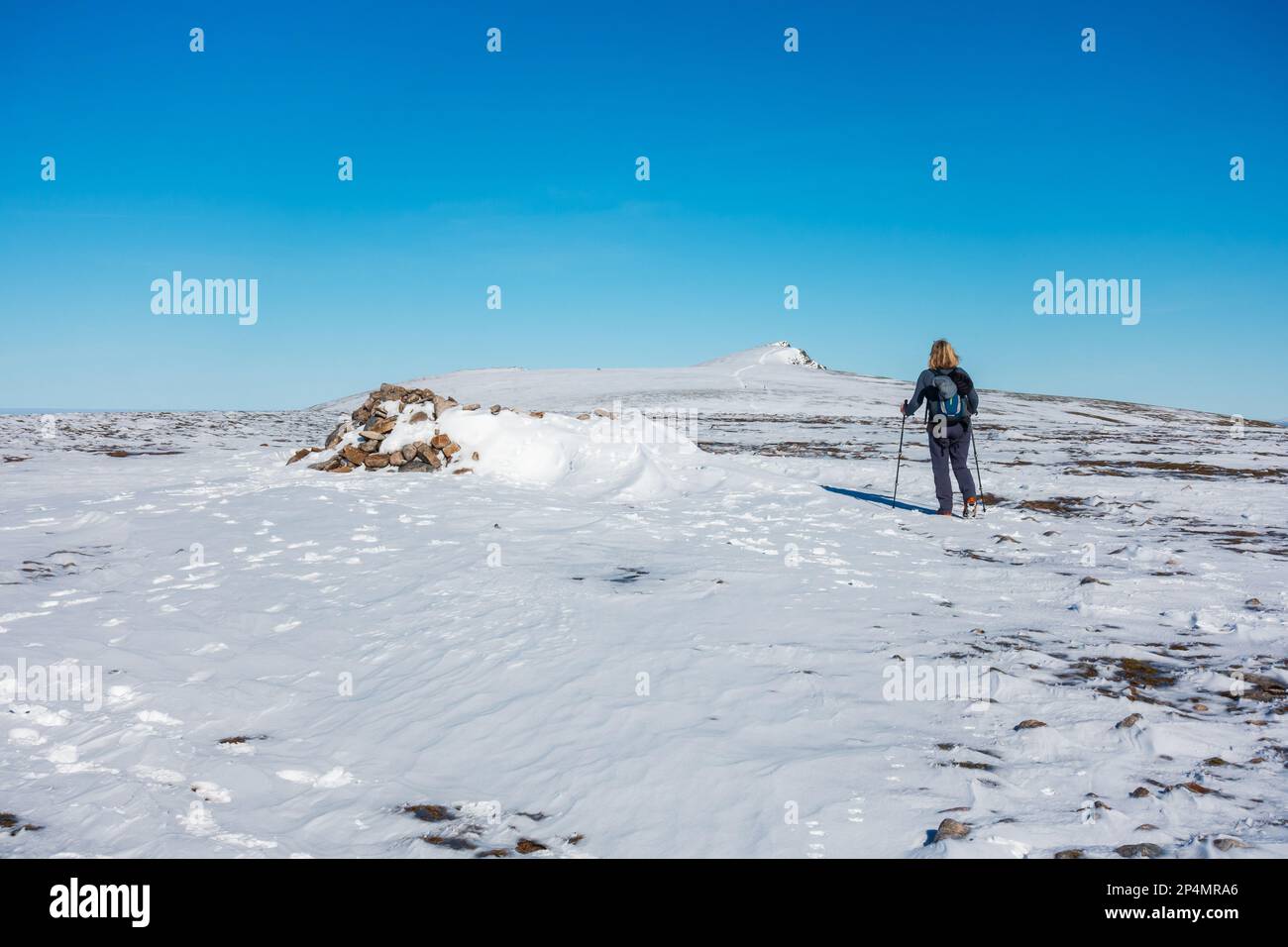 Walker passes the shelter cairn on the path to the summit of the ...