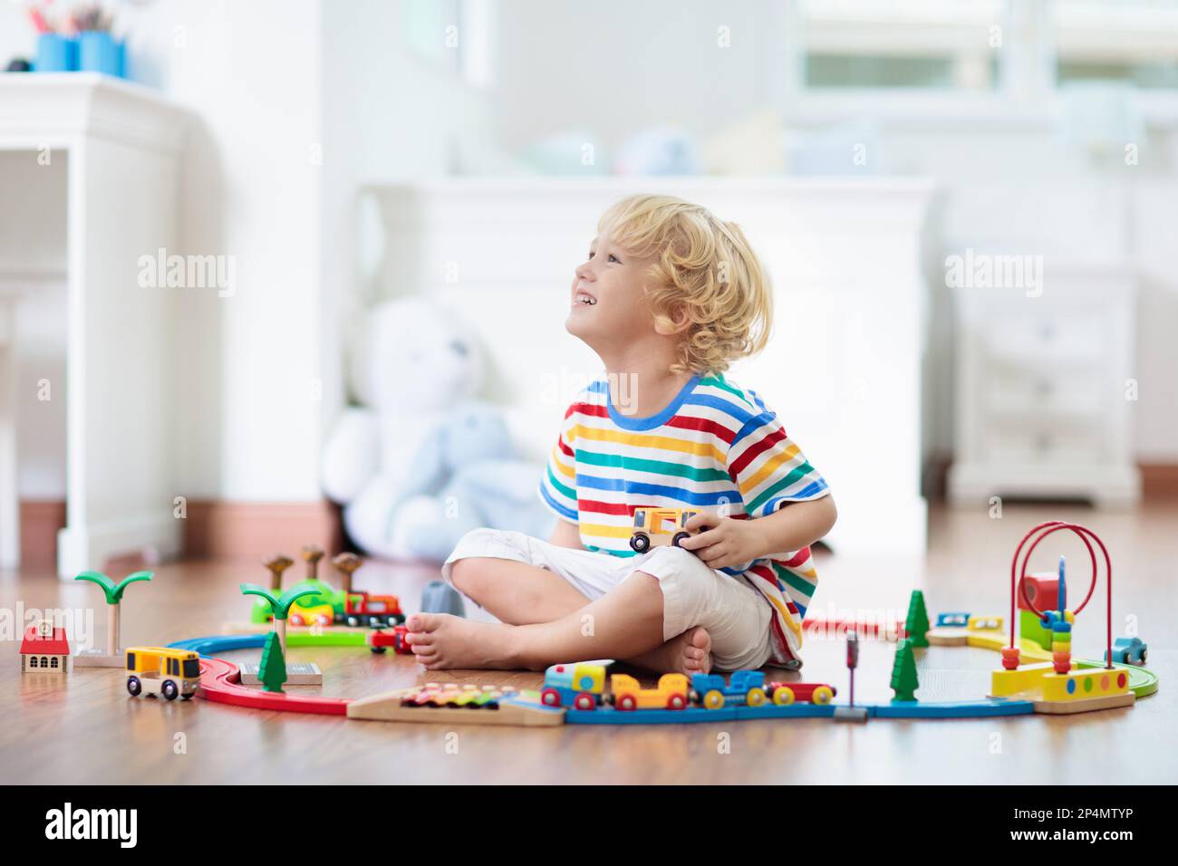 Kids play with wooden railway. Child with toy train. Educational toys ...