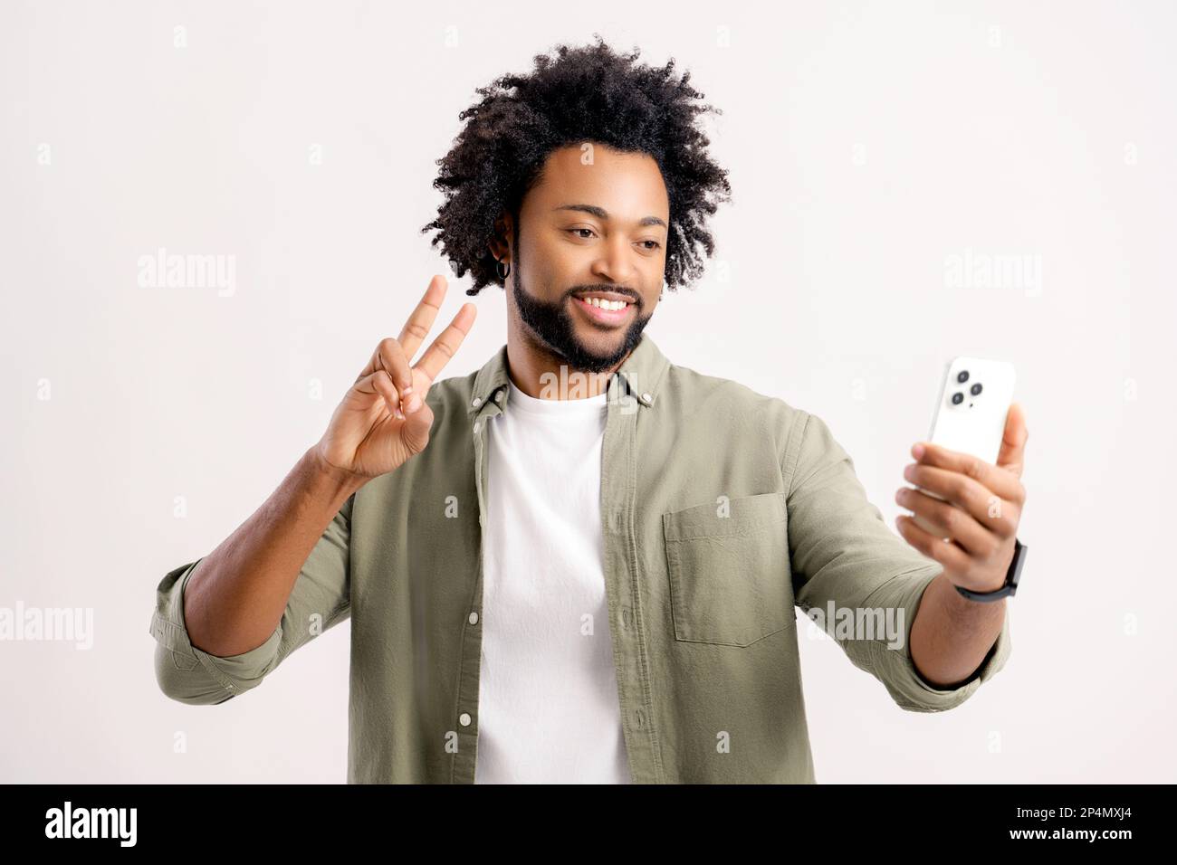 Handsome attractive 30s guy taking selfie by smartphone, showing peace ...