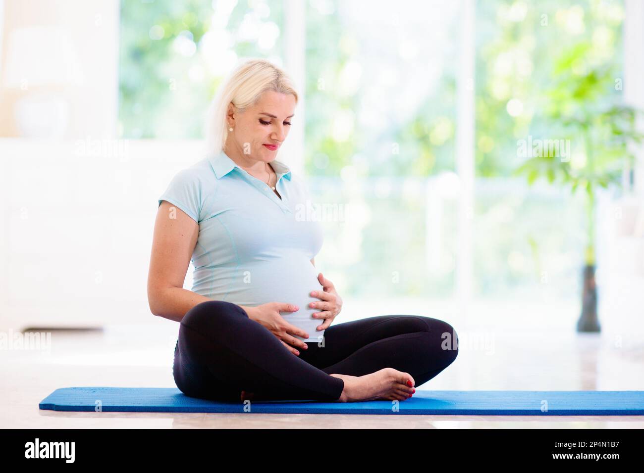 Pregnancy yoga. Exercise for pregnant woman. Active young female ...