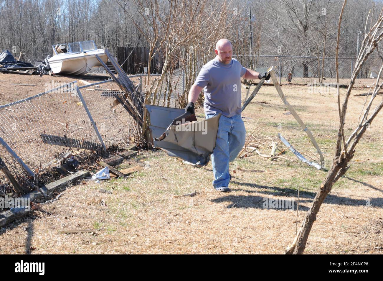 Timothy Ballinger picks up debris from his Greenvalley Circle yard as a ...