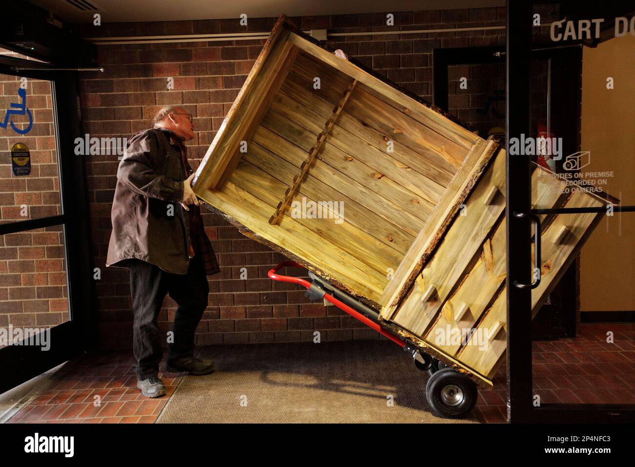 Monte Pittman hauls a rifle rack that he constructed out of pine into ...