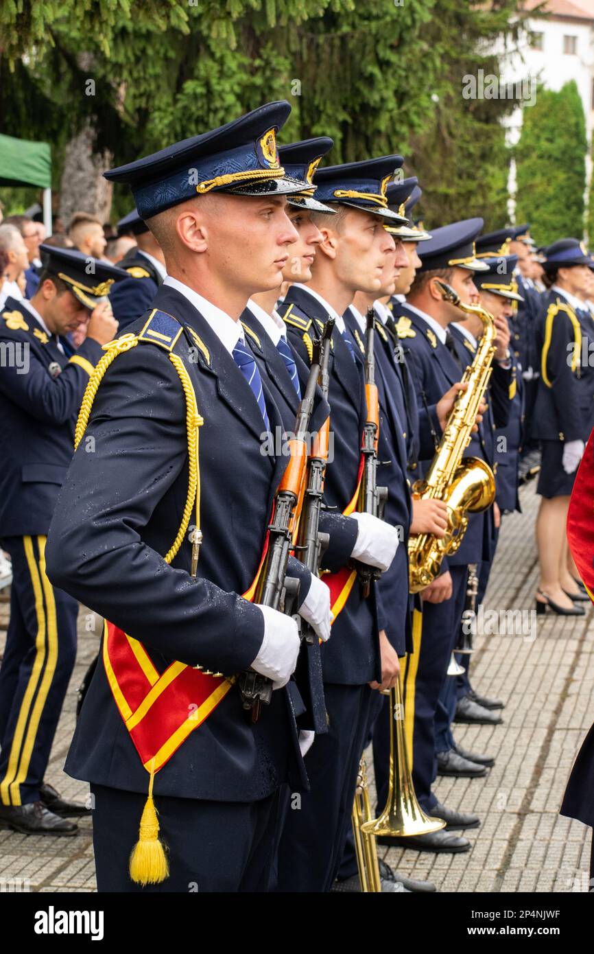 A group of soldiers wearing matching uniforms and hats stand in a neat ...