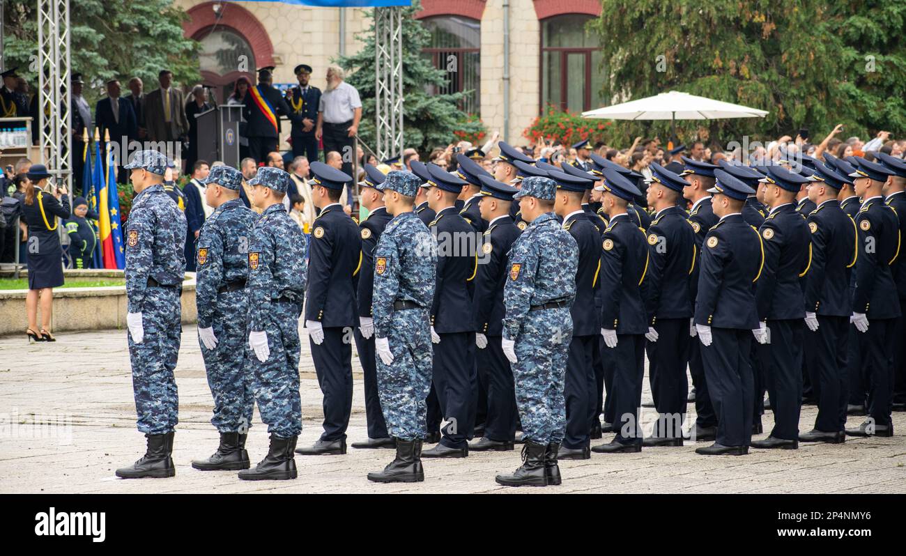 A group of soldiers in uniform, standing with a senior officer behind ...