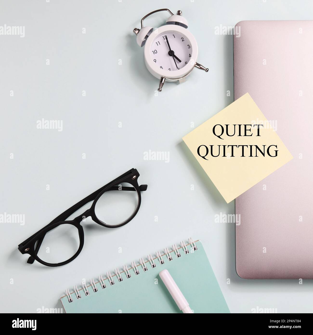 quote 'Quiet quitting' on yellow sticker on computer with clock and ...