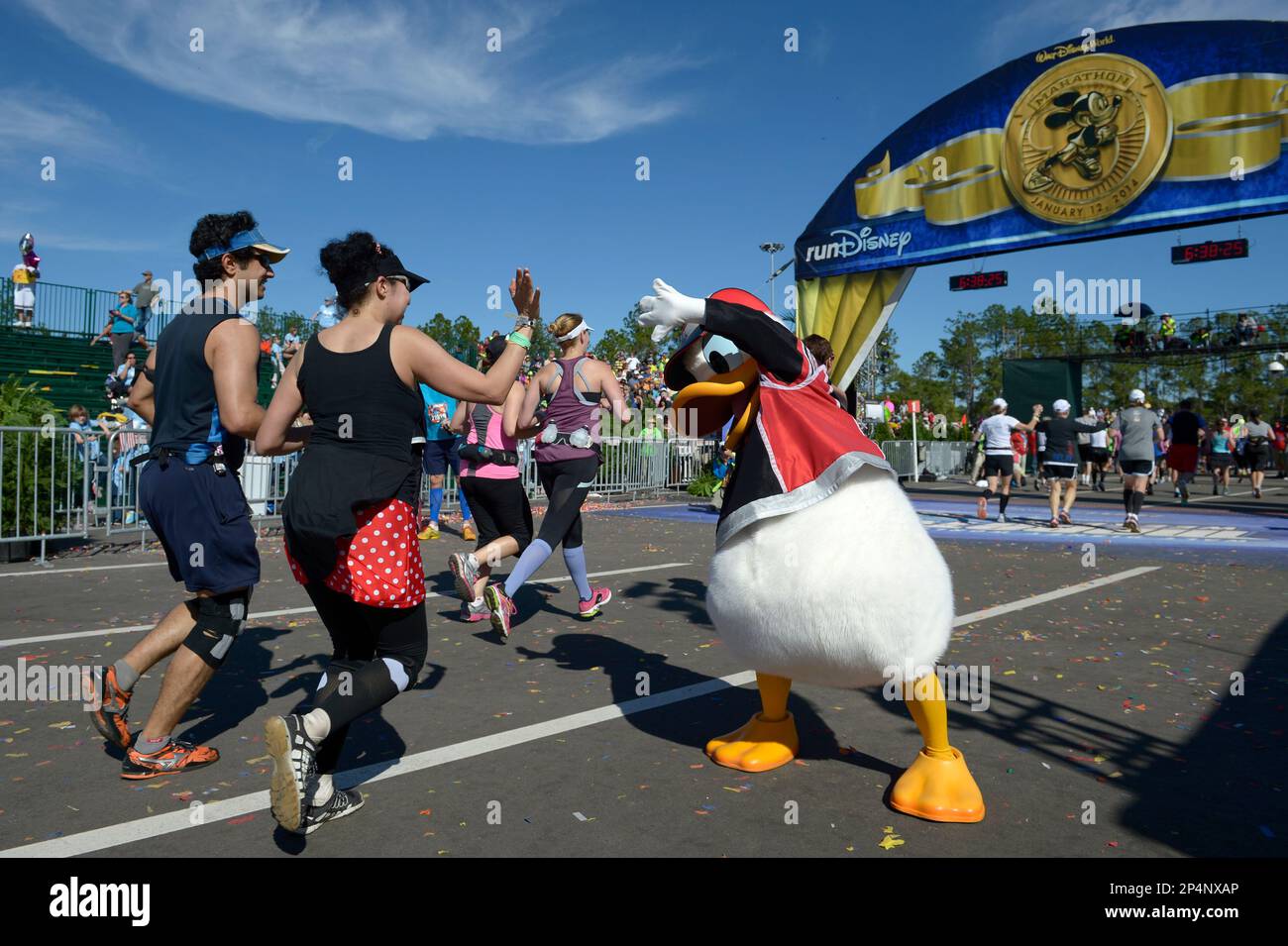 Runners are met by an actor dressed as Donald Duck, right, at the ...