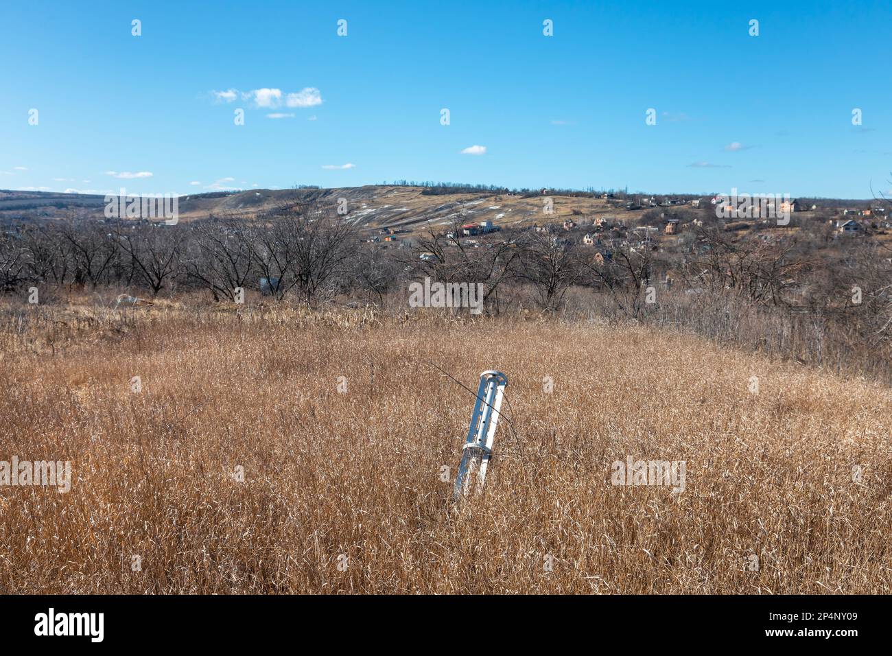 Wartime signs. Unexploded shell seen in the middle of a field. Remains ...