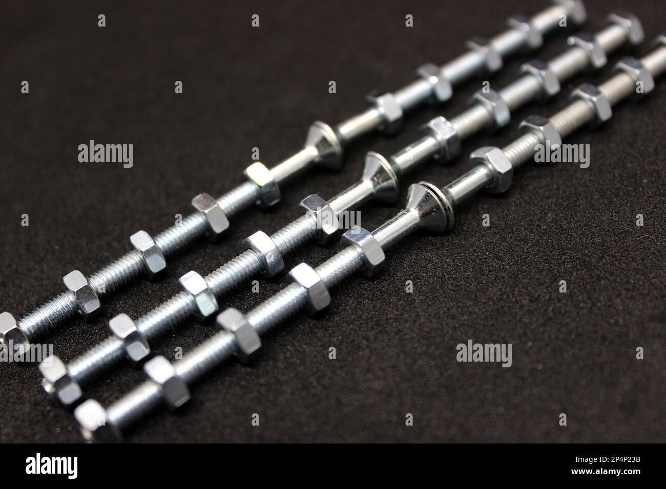 Shiny Iron Bolts With Nuts Screwed On Them Lie In Even Rows Isolated On ...