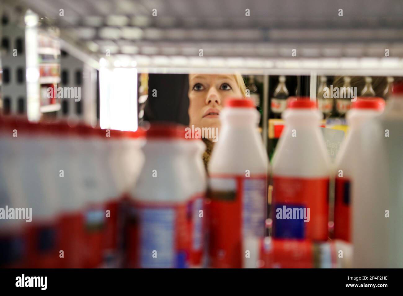Jennifer Poulos reaches in the dairy shelves, Monday, Feb. 10, 2014, in ...