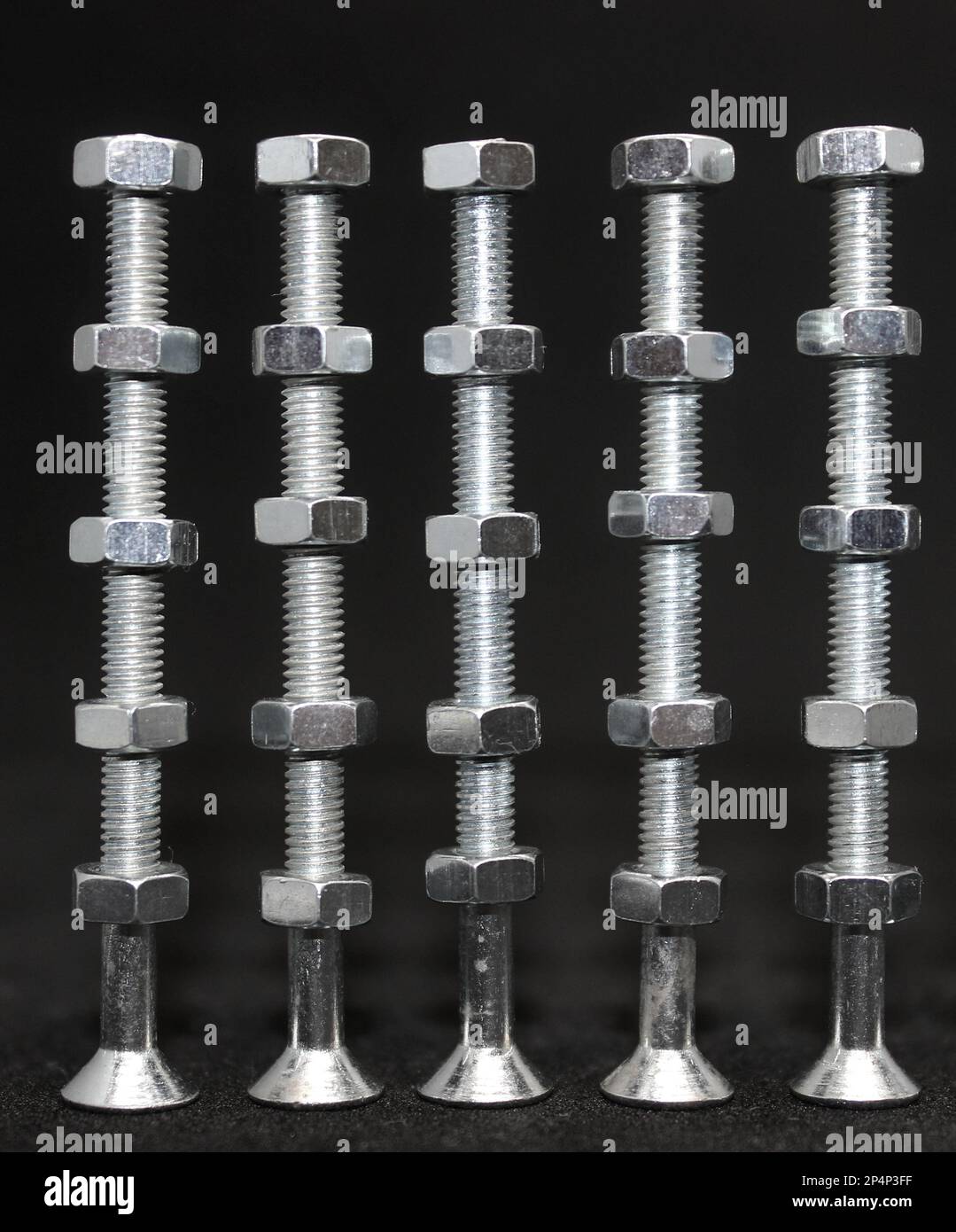 Metal Nuts On A Screw Bolts Isolated On Black Stock Photo For Vertical ...