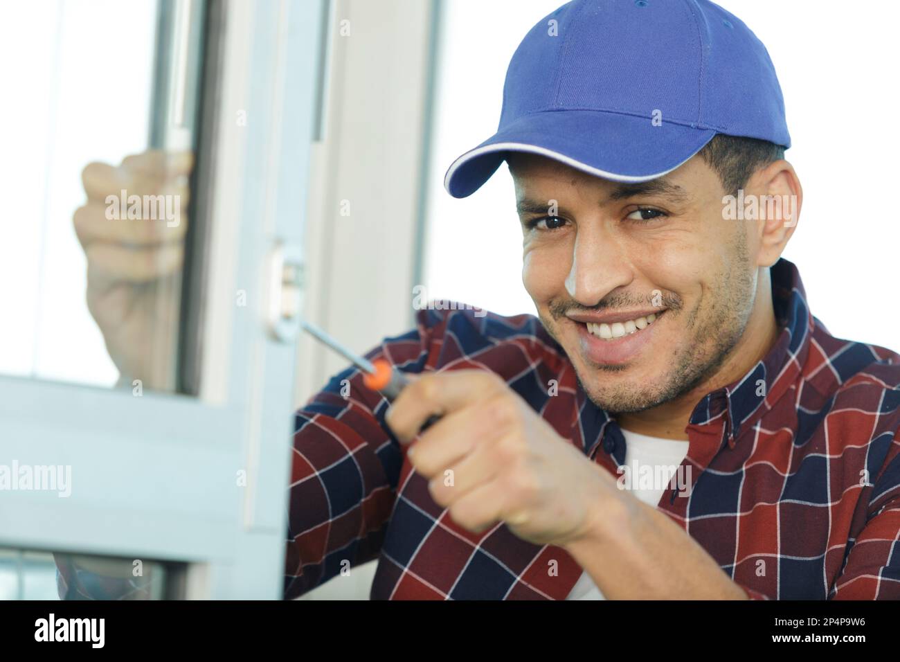 man screws a pvc window Stock Photo - Alamy