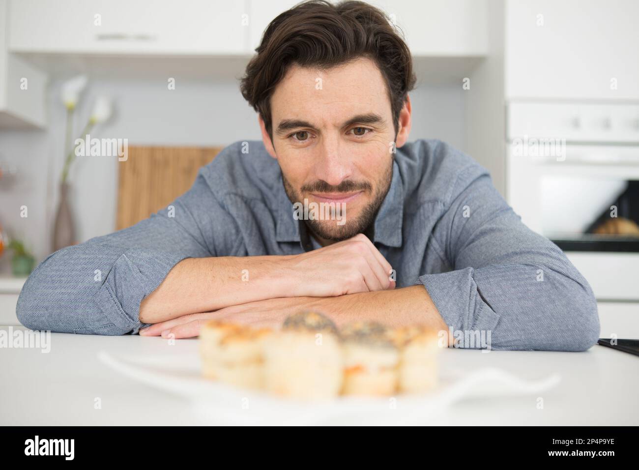 man looking longingly at a plate of vol-au-vents Stock Photo - Alamy