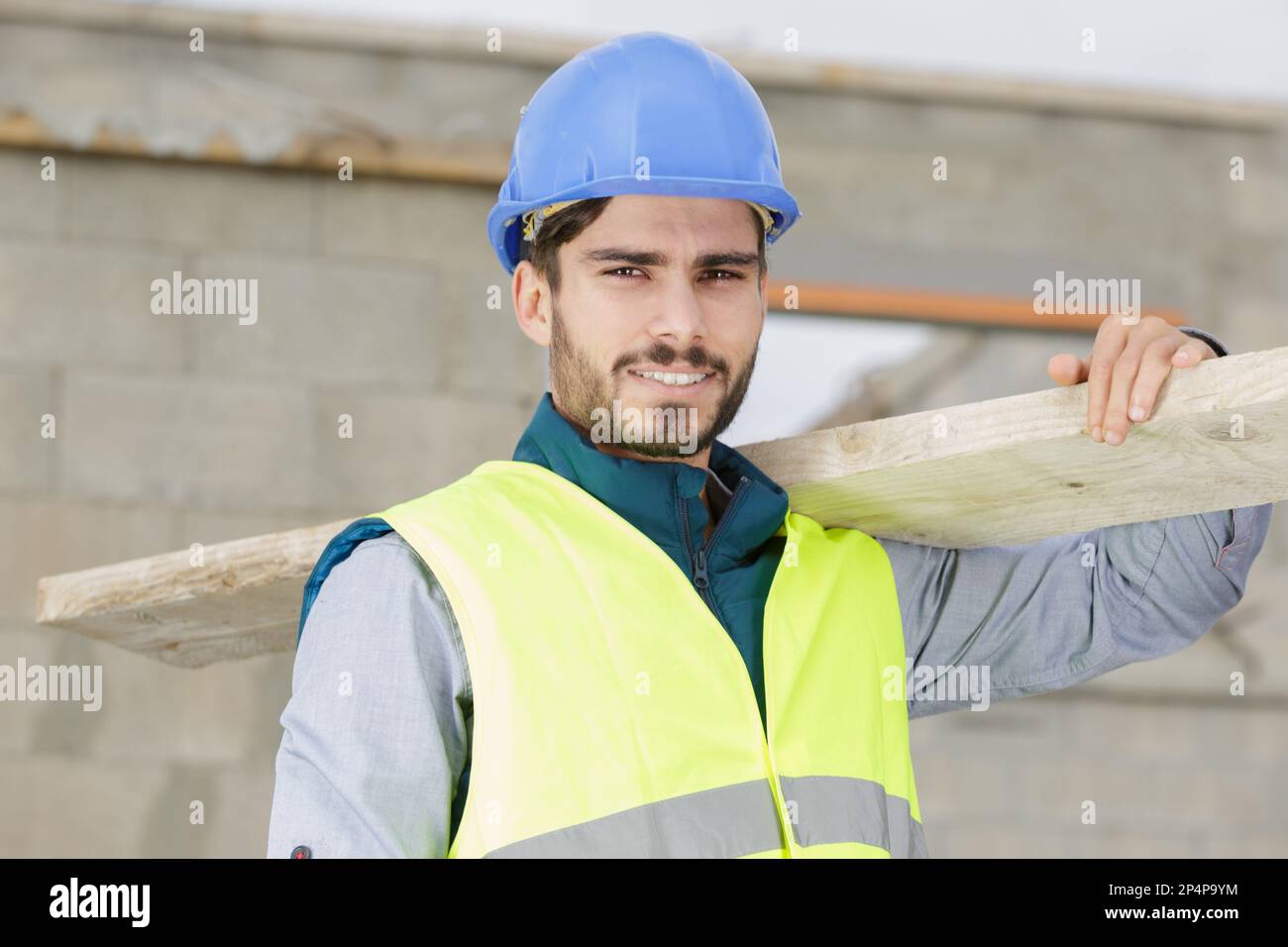builder and apprentice carrying wood on construction site Stock Photo ...