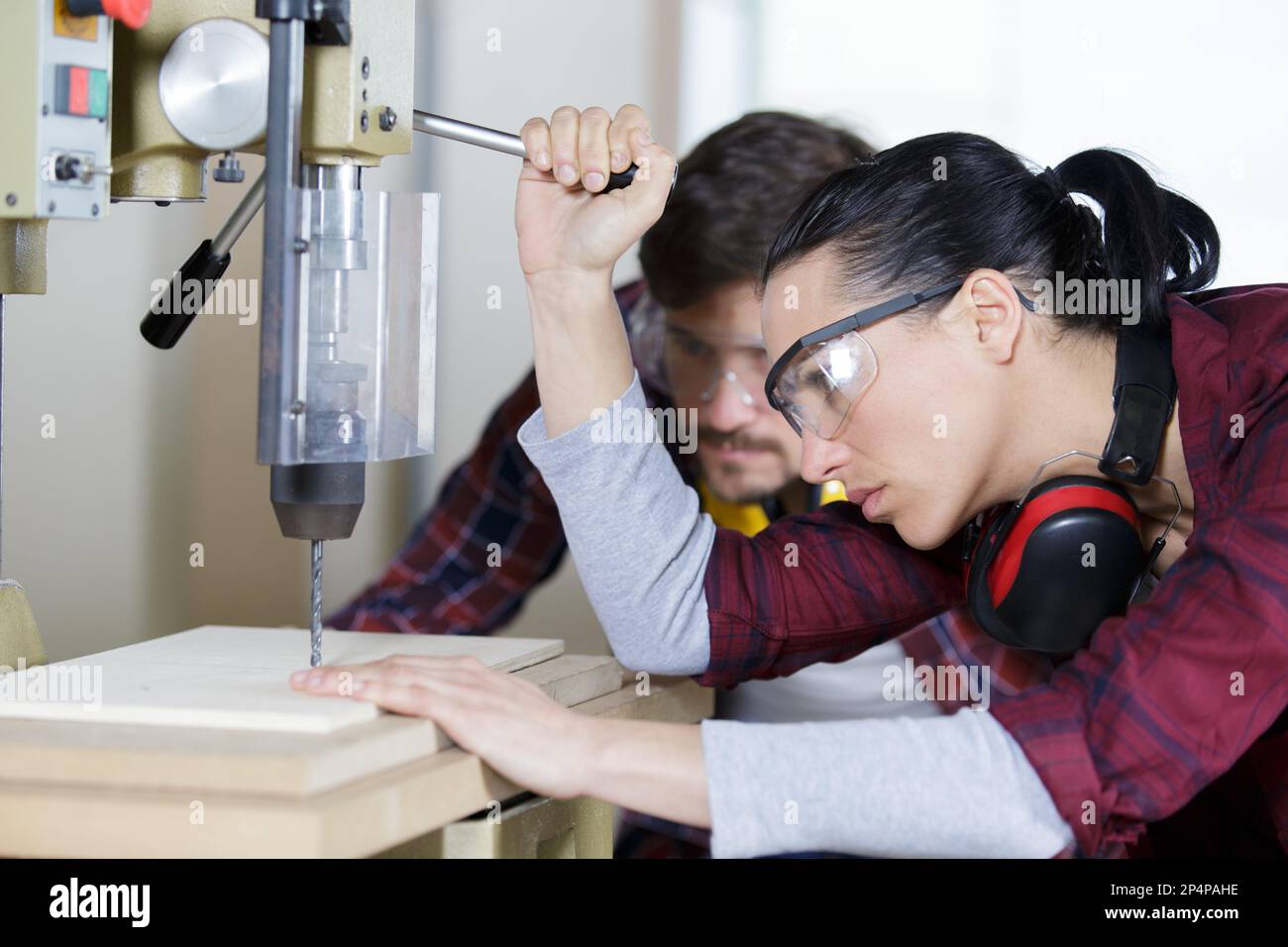 woman using bench drill under supervision Stock Photo - Alamy