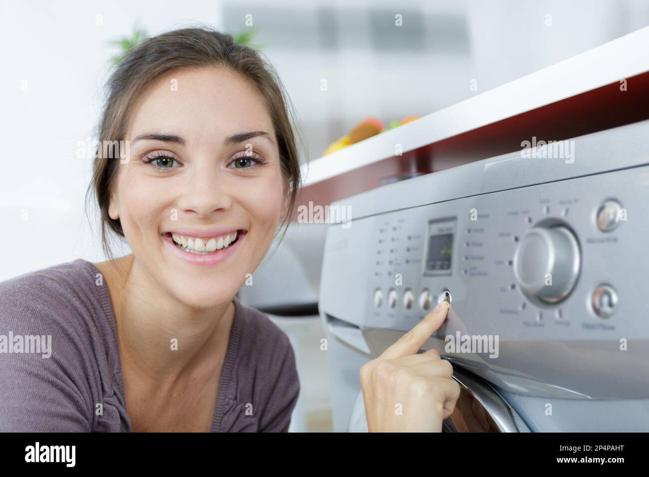 close view of woman pressing button on washing machine Stock Photo - Alamy