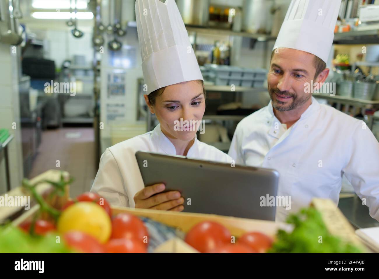 restaurant manager showing tablet to chef Stock Photo - Alamy