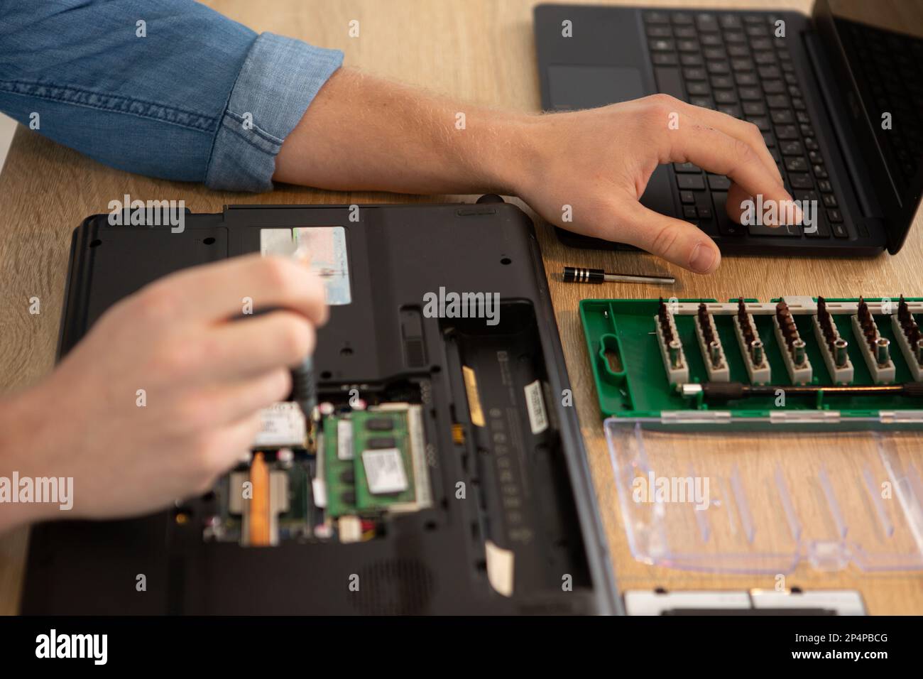 repairman disassembling laptop motherboard with tools Stock Photo - Alamy