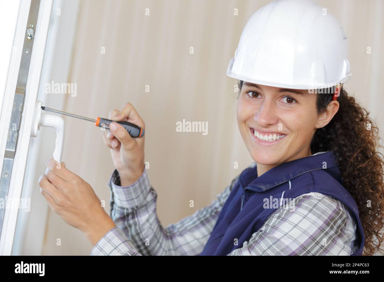 female builder looking at a window Stock Photo - Alamy