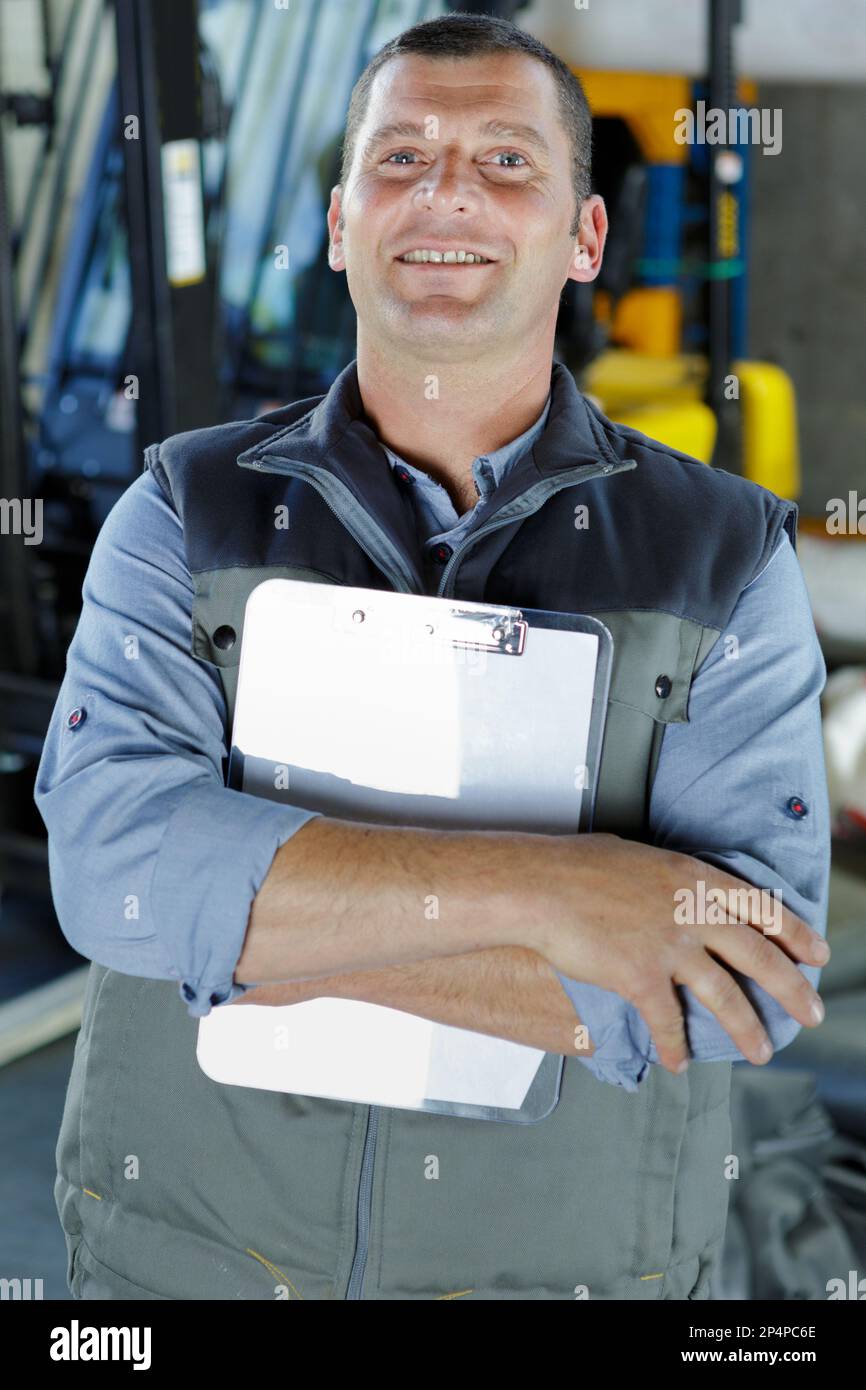 portrait of male warehouse worker holding clipboard Stock Photo - Alamy