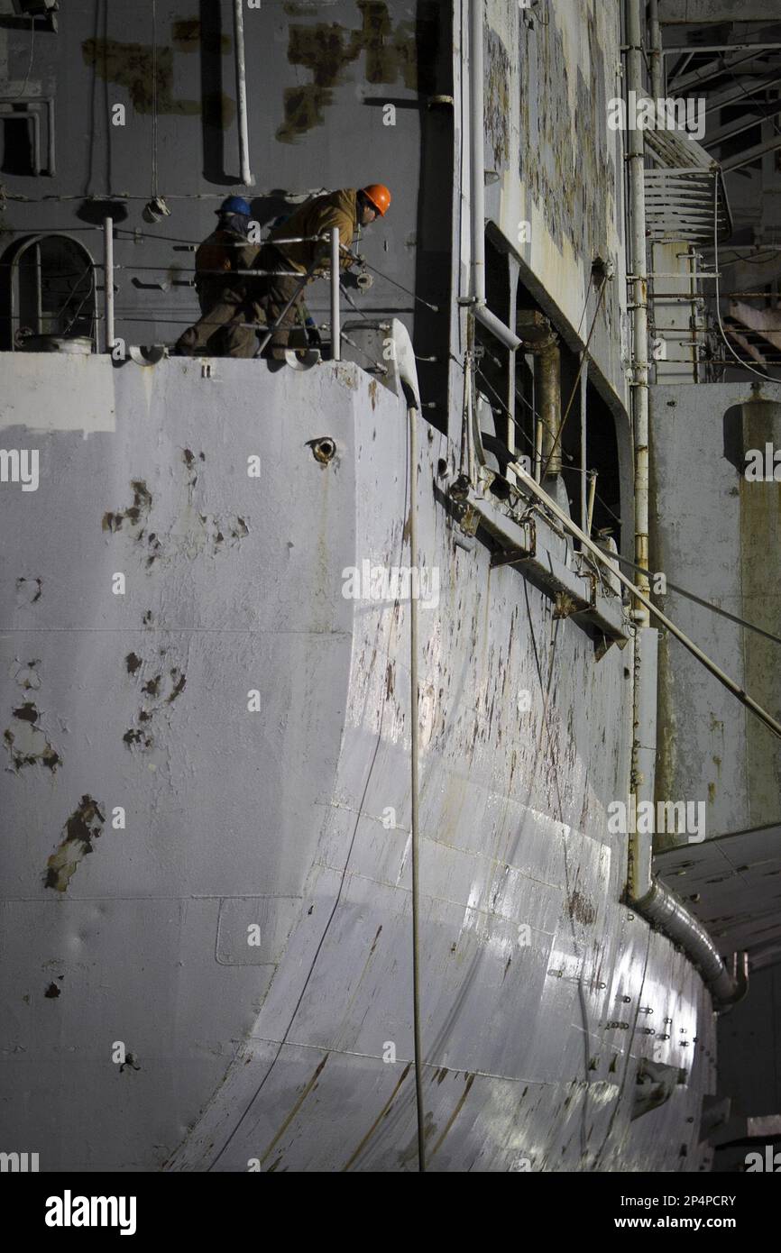 Work crews with Foss Marine Towing untie the decommissioned aircraft ...