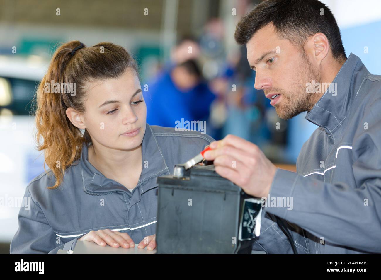 women and man checking battery in garage Stock Photo - Alamy